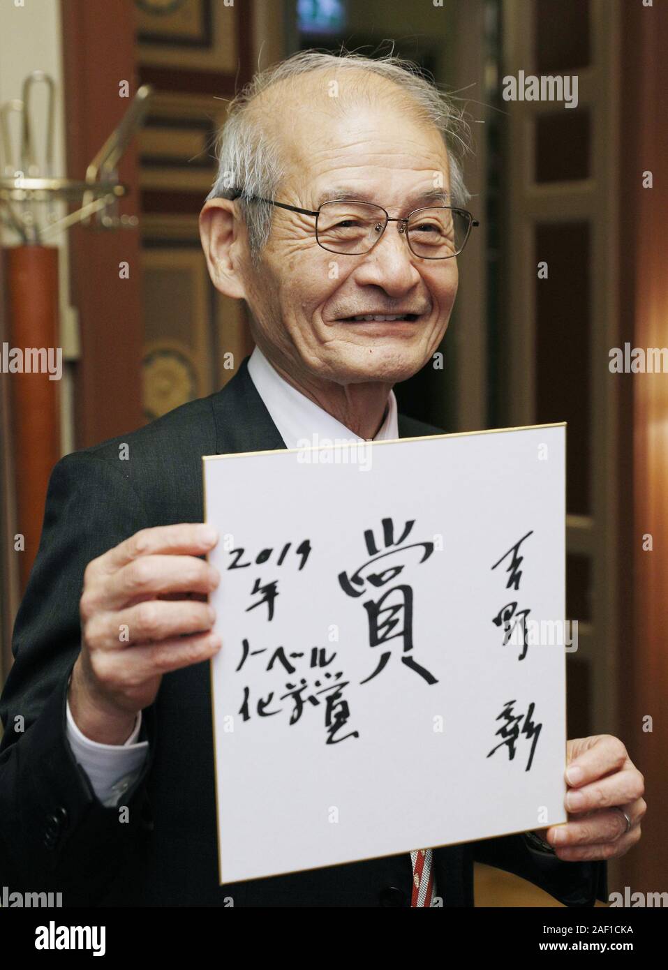 Japanese scientist Akira Yoshino shows reporters a card bearing his ...