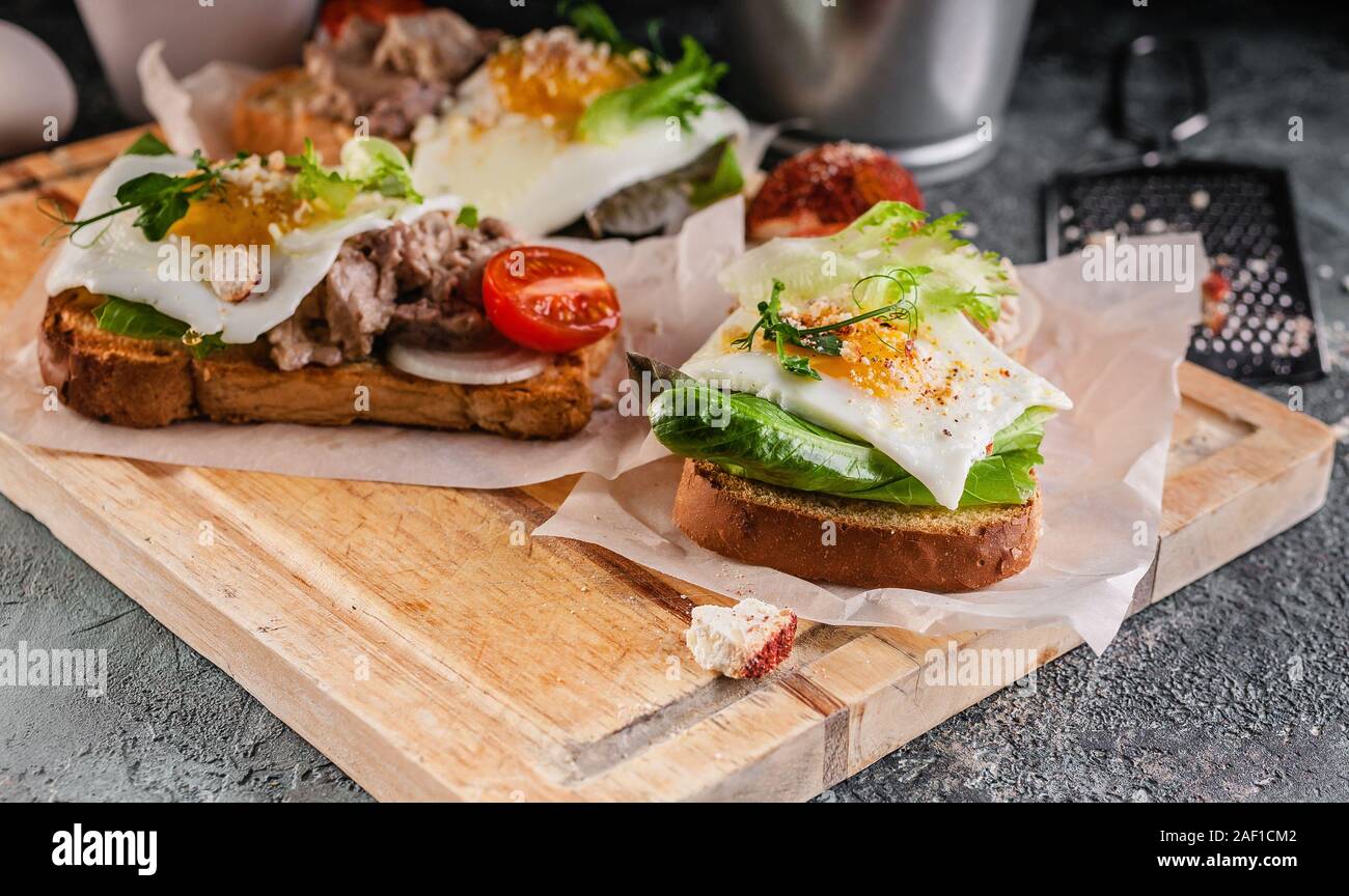 Delicious cod liver sandwiches with fried eggs, lettuce, cherry ...
