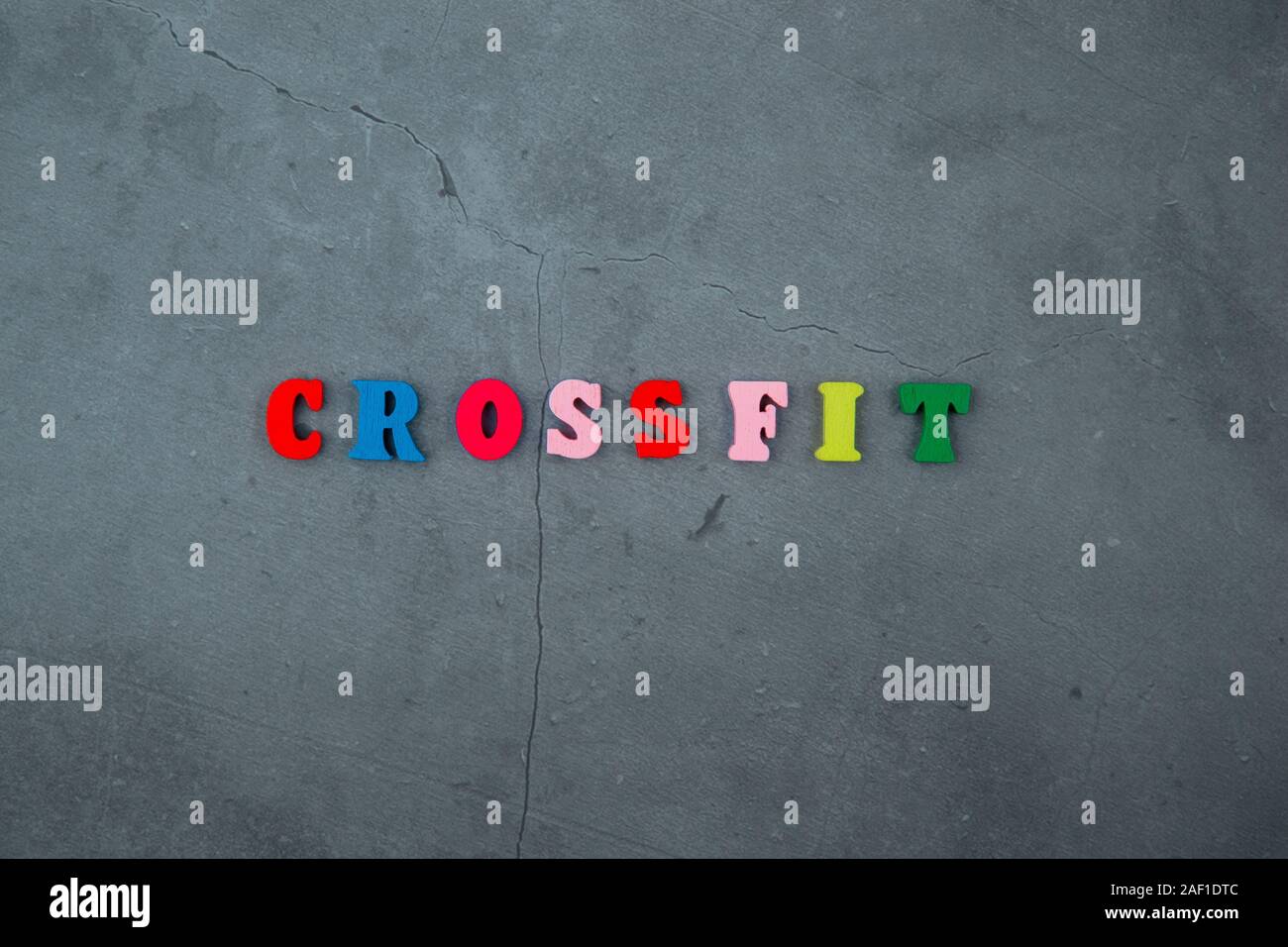 The multicolored crossfit word is made of wooden letters on a grey ...
