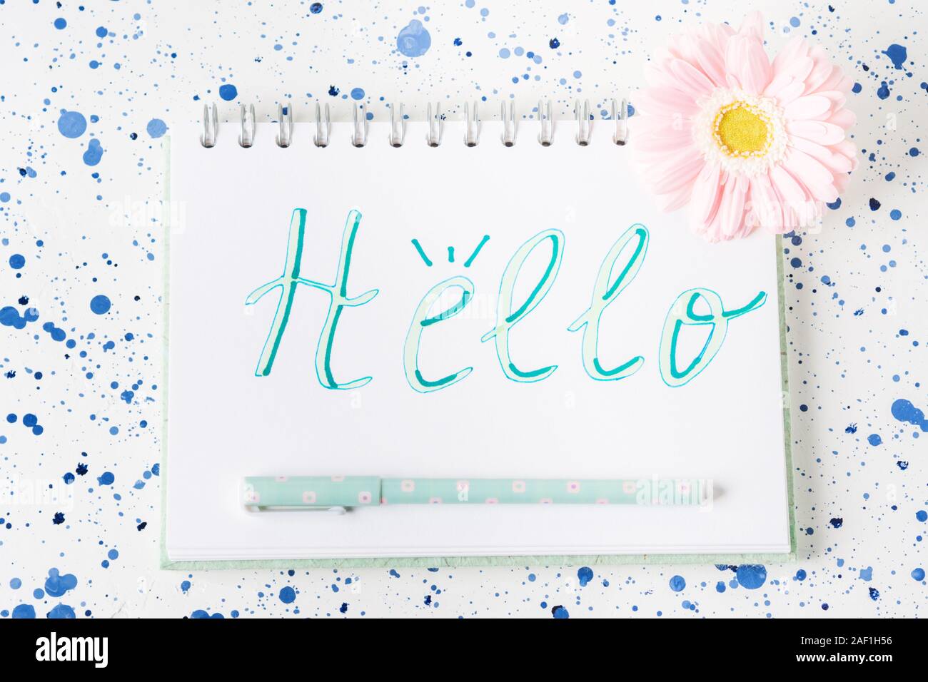 Hello word written with hand lettering on notebook page. Gerbera ...