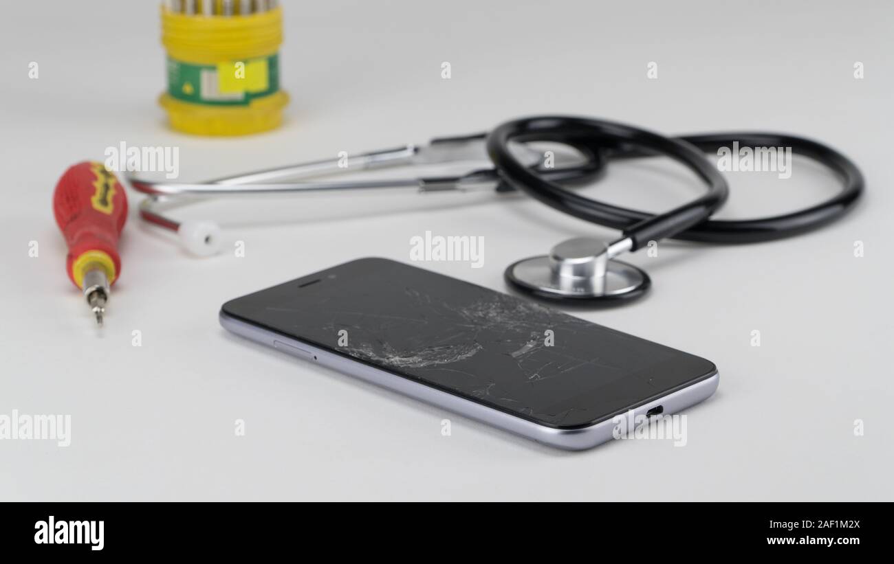 Diagnosing the phone with a stethoscope, near a screwdriver. Phone ...