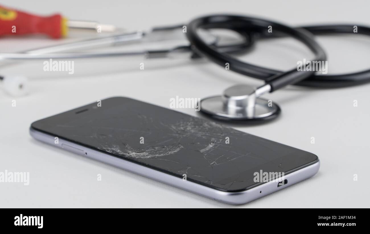 Diagnosing the phone with a stethoscope, near a screwdriver. Phone ...