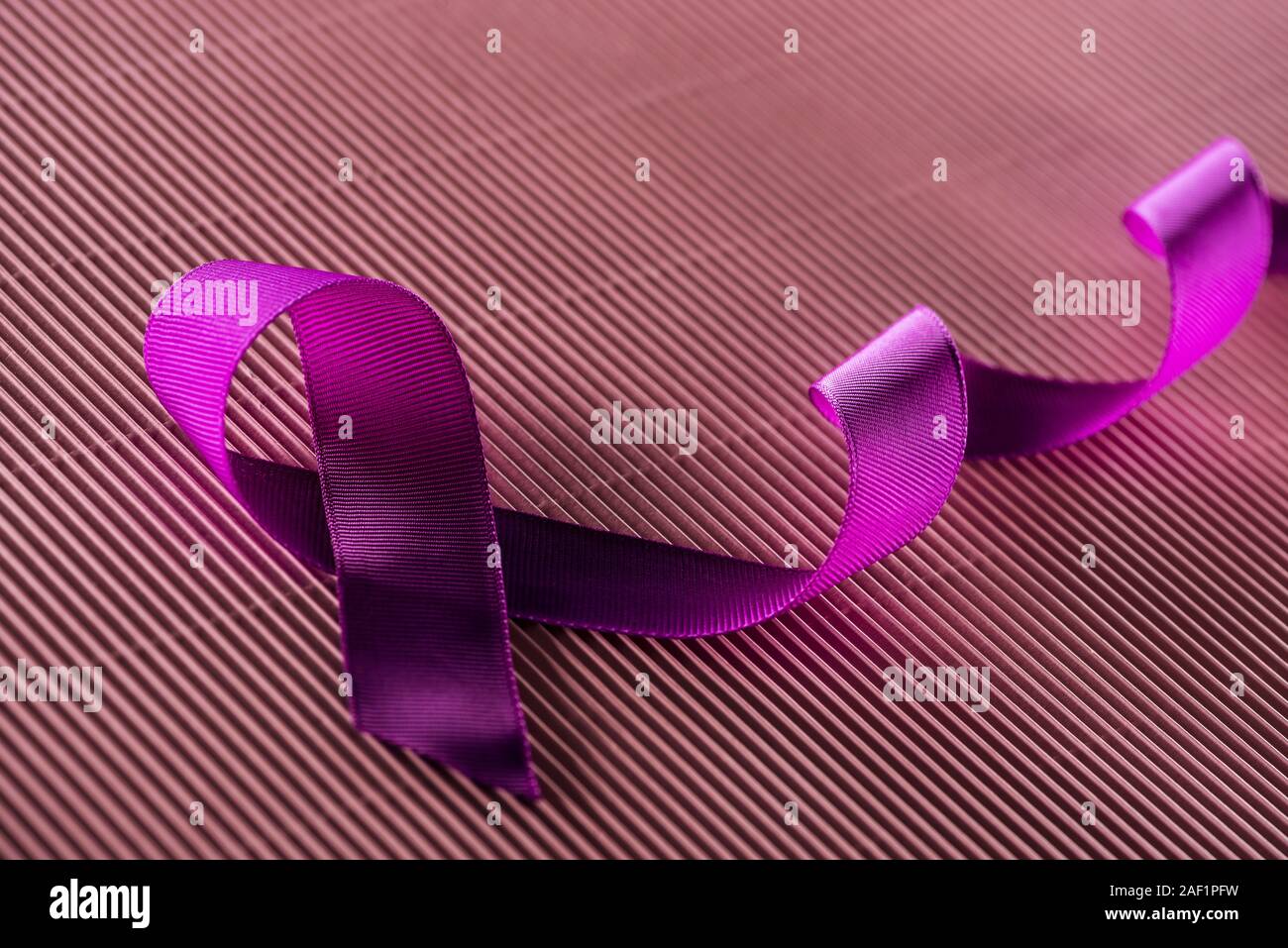 purple ribbon on pink texture background in shadow Stock Photo - Alamy