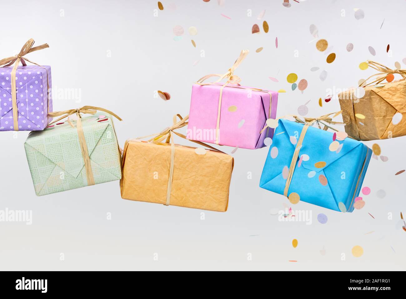 falling colorful confetti near wrapped presents on white Stock Photo ...