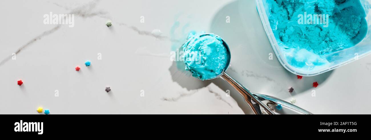 top view of delicious blue ice cream with sprinkles in box with ice ...