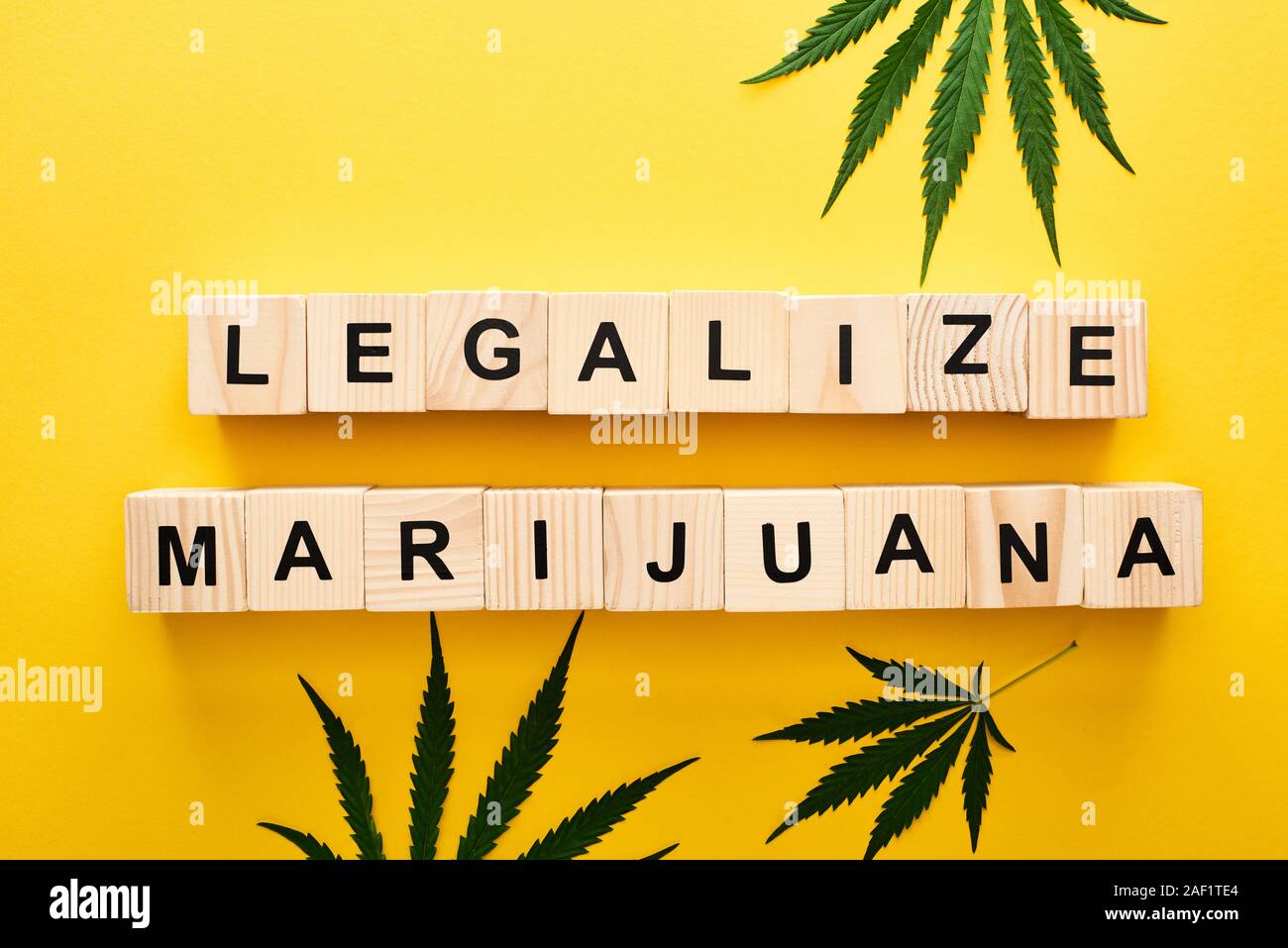 top view of cannabis leaves and wooden blocks with legalize marijuana ...