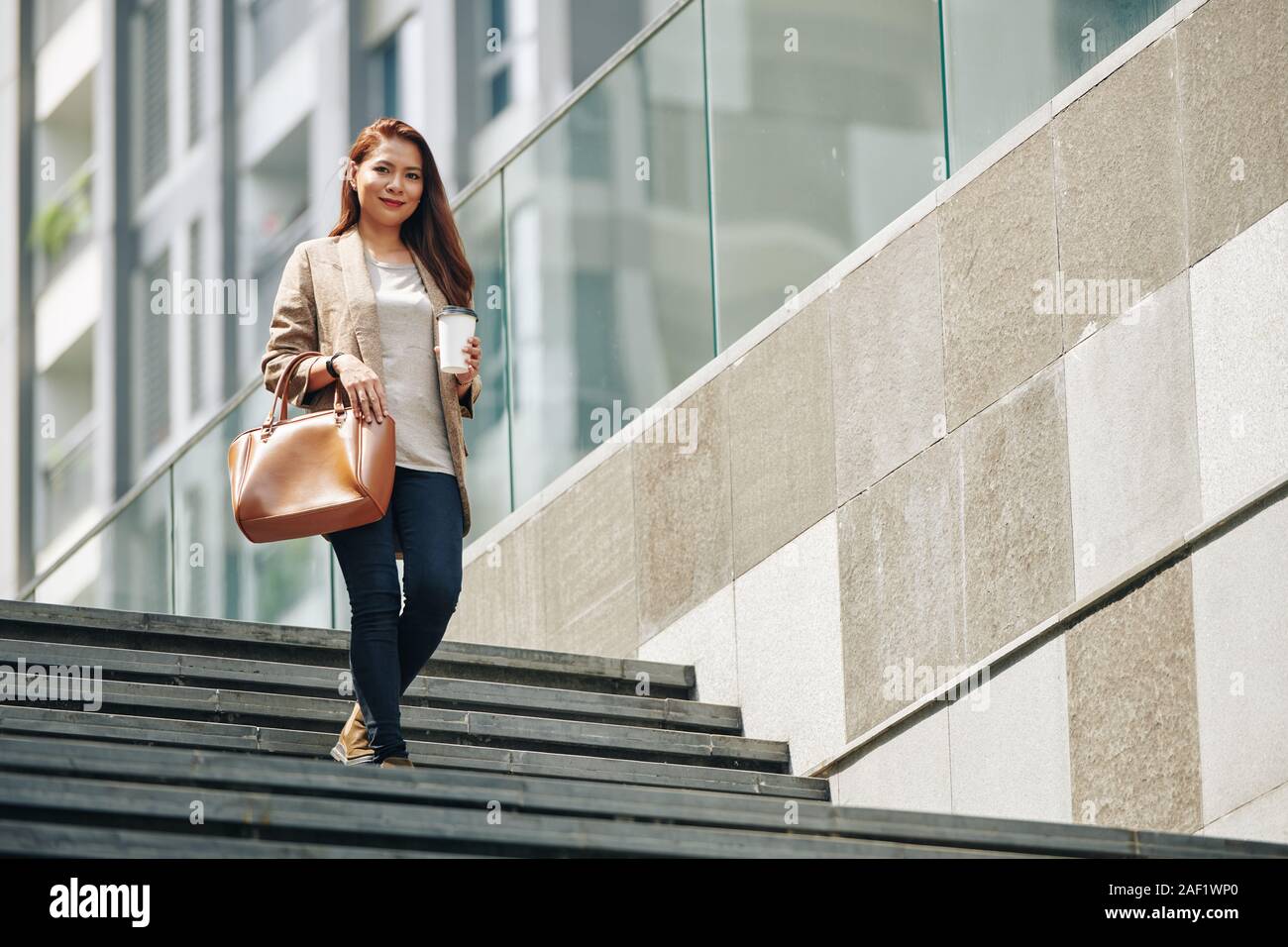 Beautiful smiling Vietnamese woman enjoying tasty take away coffee when ...
