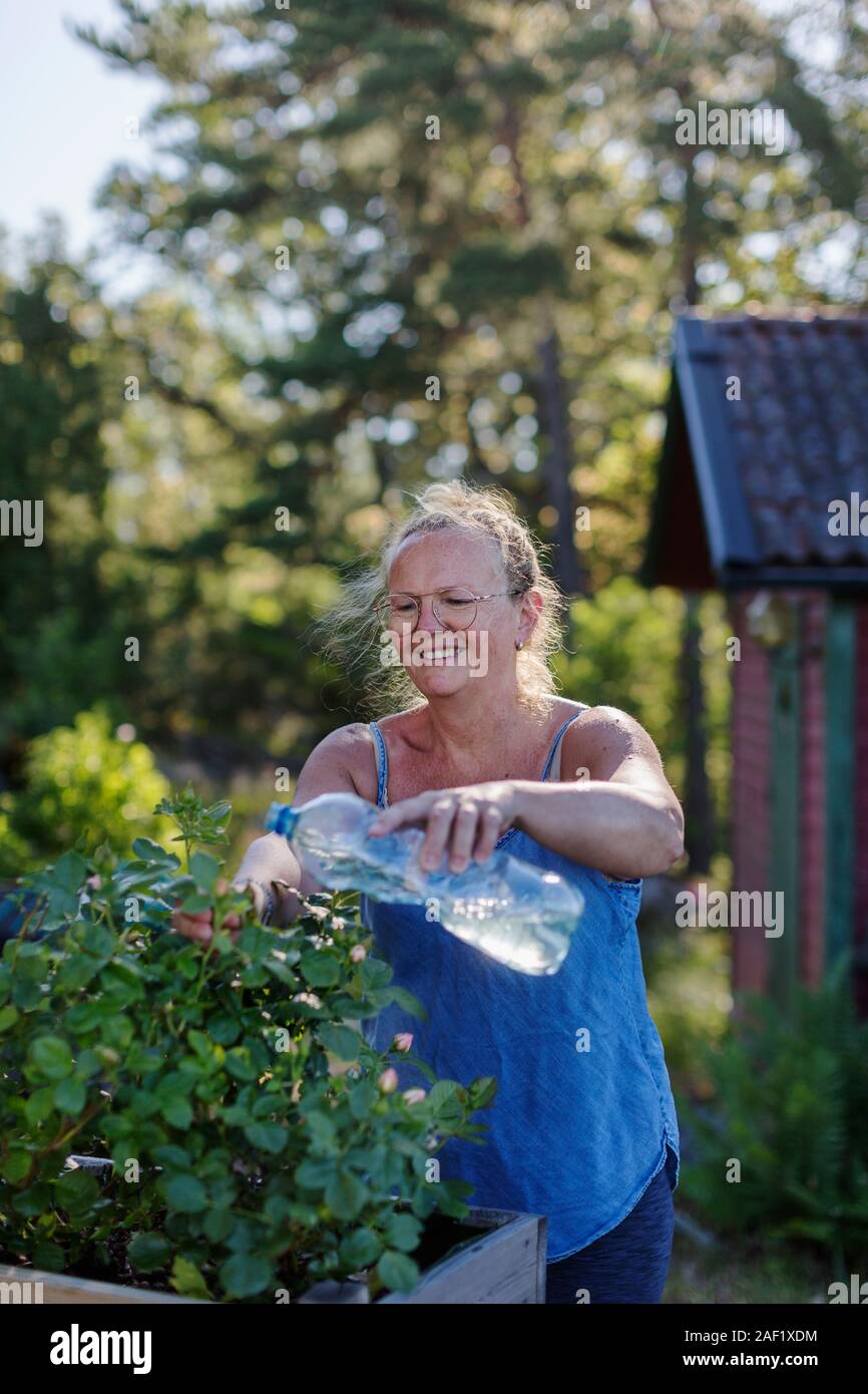 Mature woman watering in hi-res stock photography and images - Alamy
