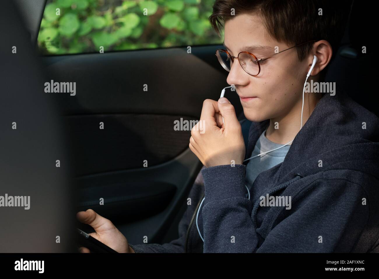 Boy using cell phone in car Stock Photo - Alamy