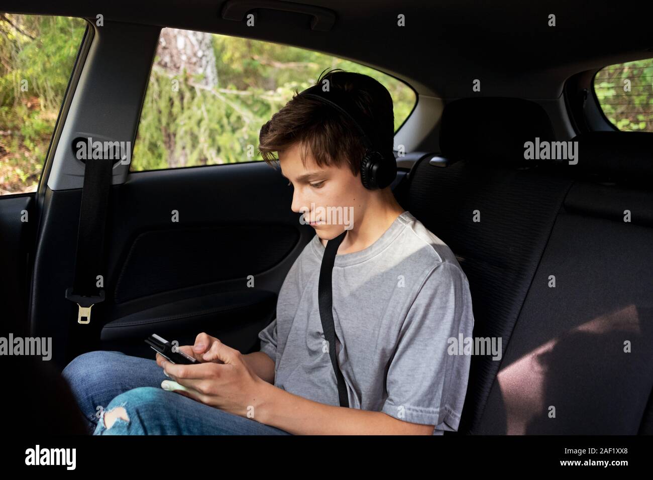 Boy using cell phone in car Stock Photo - Alamy