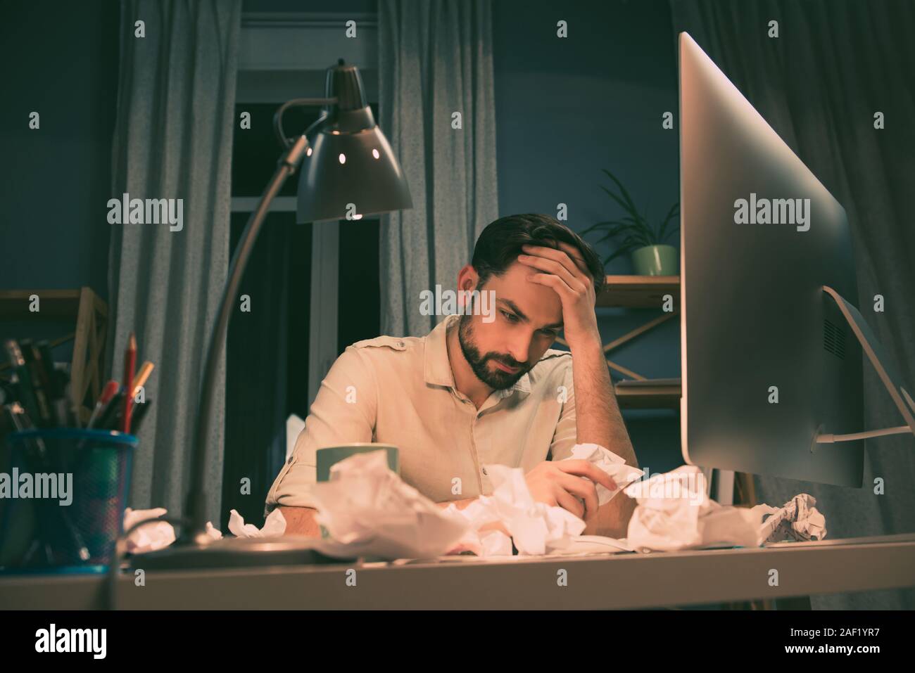 Minded sad man working at night to finish task Stock Photo - Alamy