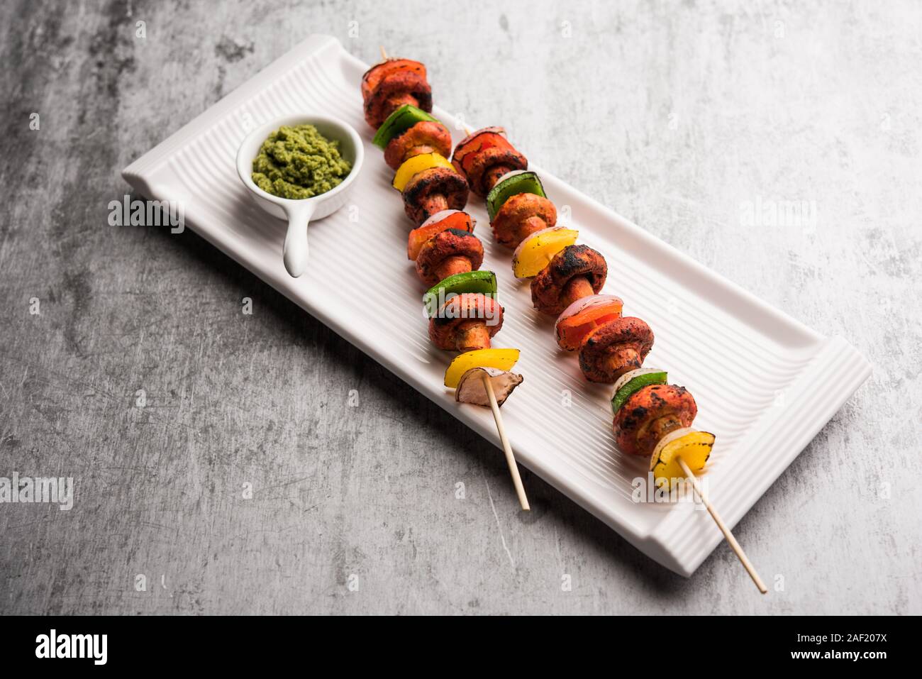 Barbecue or tandoori Mushroom Tikka, served in a plate with green ...