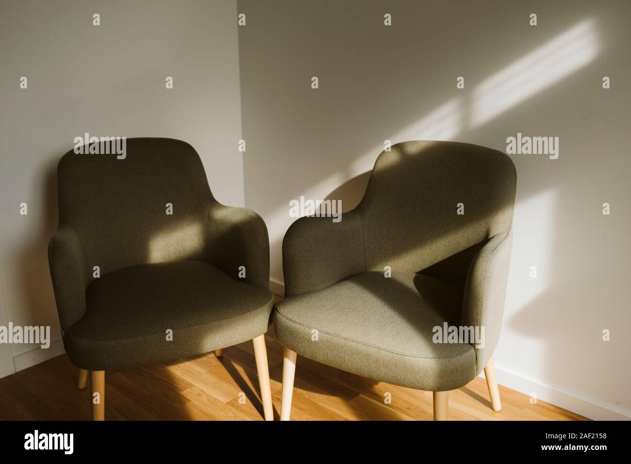 Two armchairs in corner of room Stock Photo - Alamy