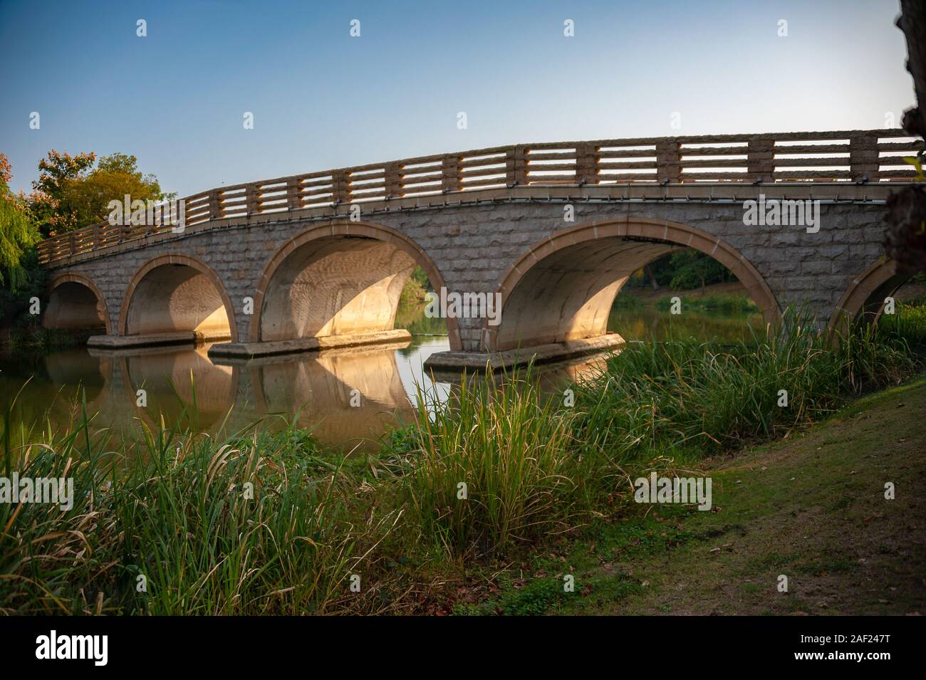 Traditional Chinese arch bridge over tranquil stream, Wuxi Taihu ...