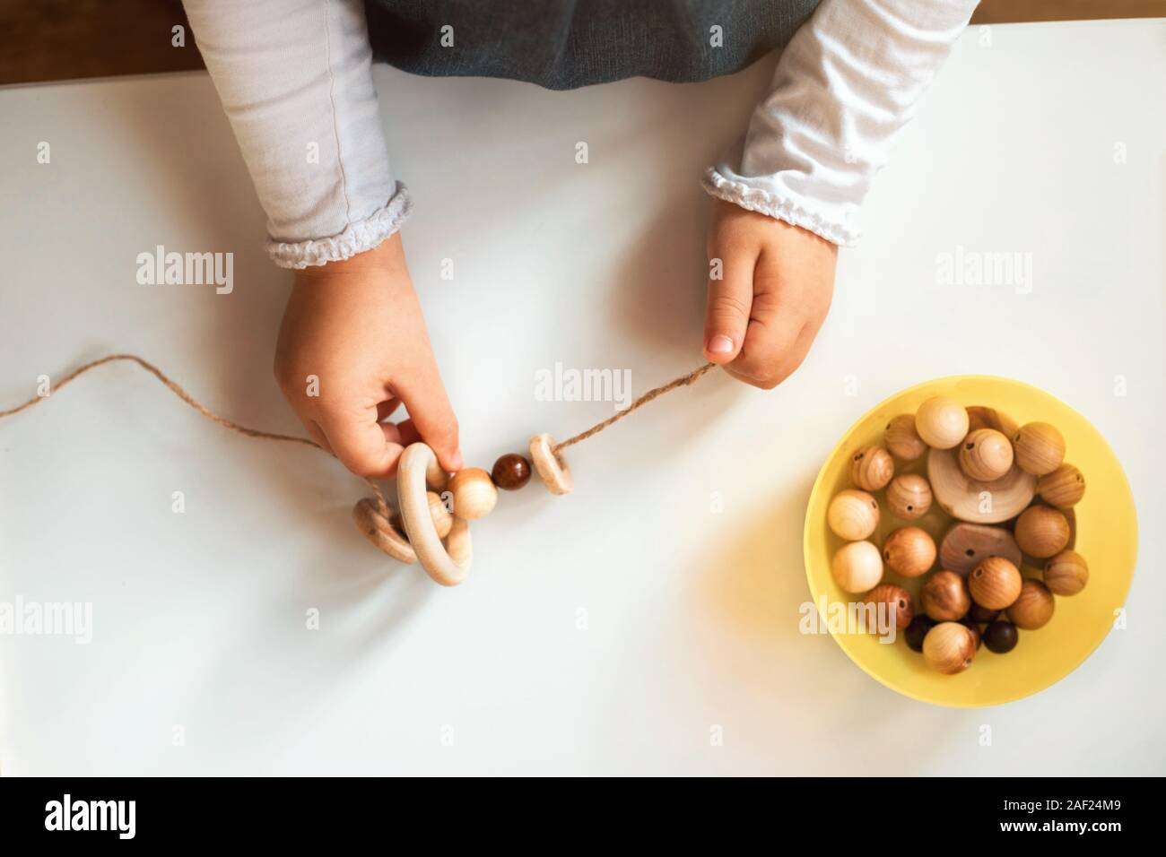 Child threading beads hi-res stock photography and images - Alamy