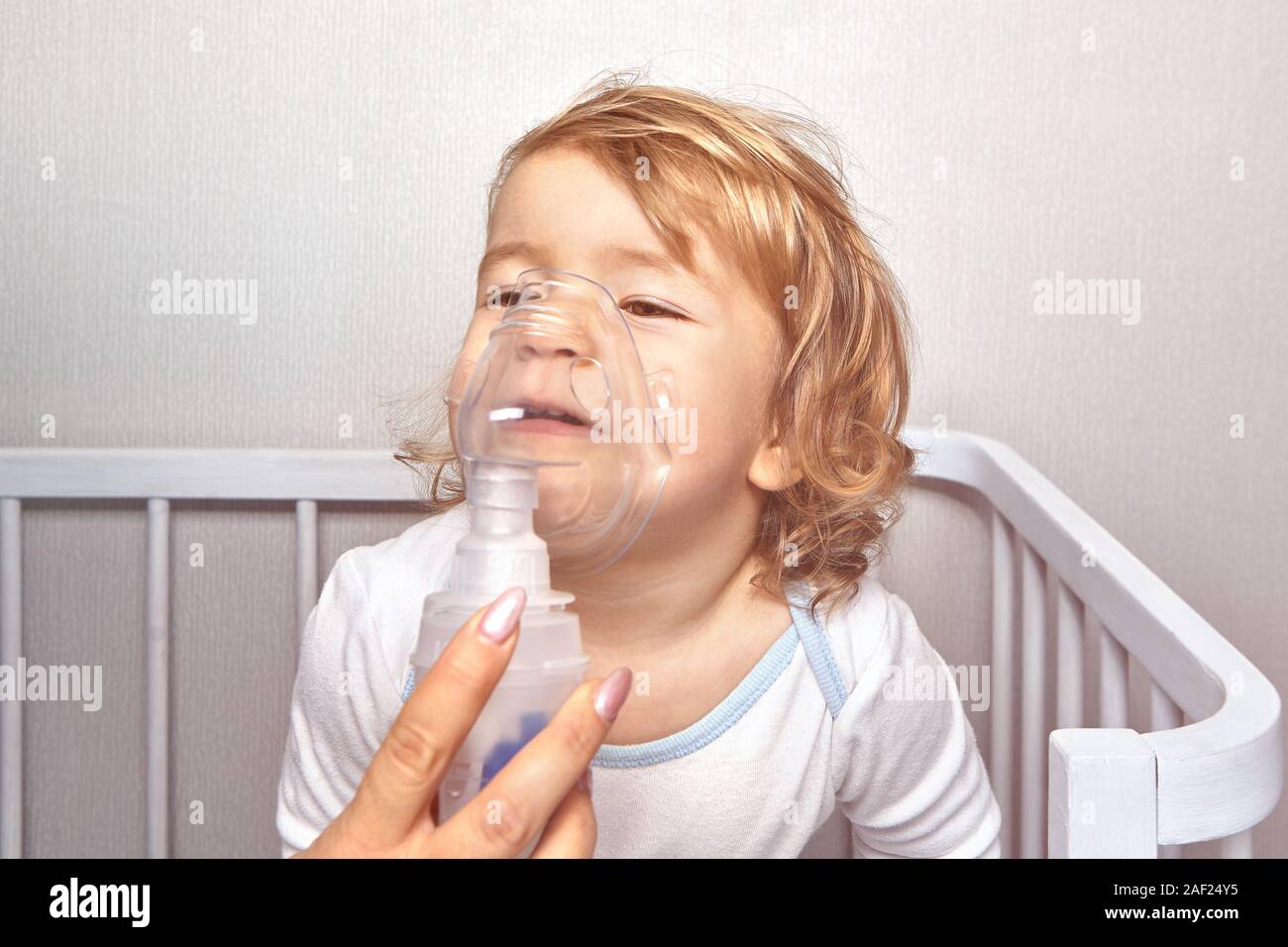 Baby caucasian girl about 1,5 years old with blond hair is breathing ...