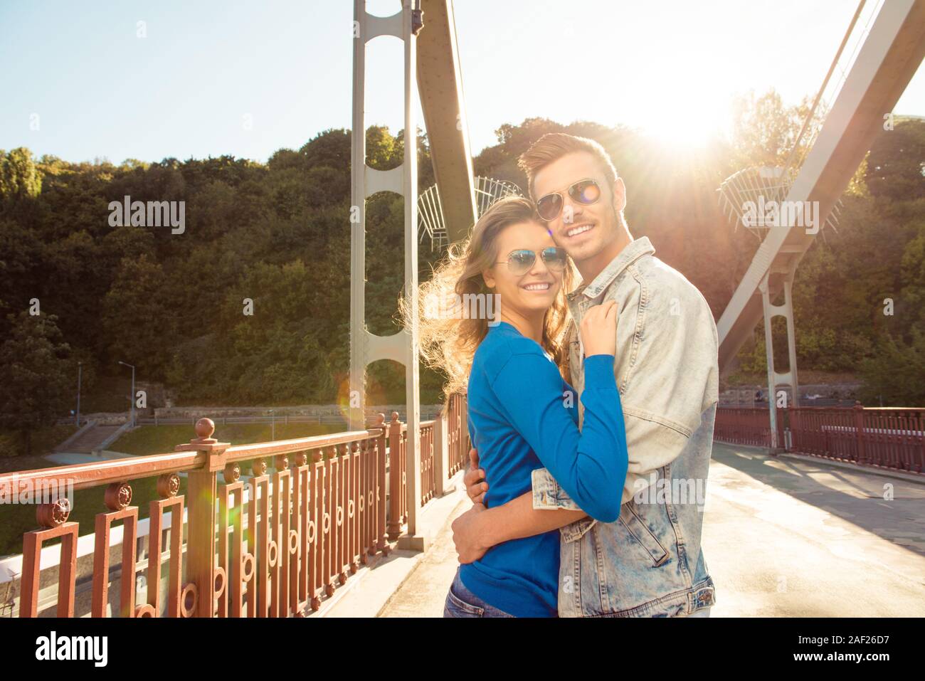Positive couple in love on the bridge huging together Stock Photo - Alamy