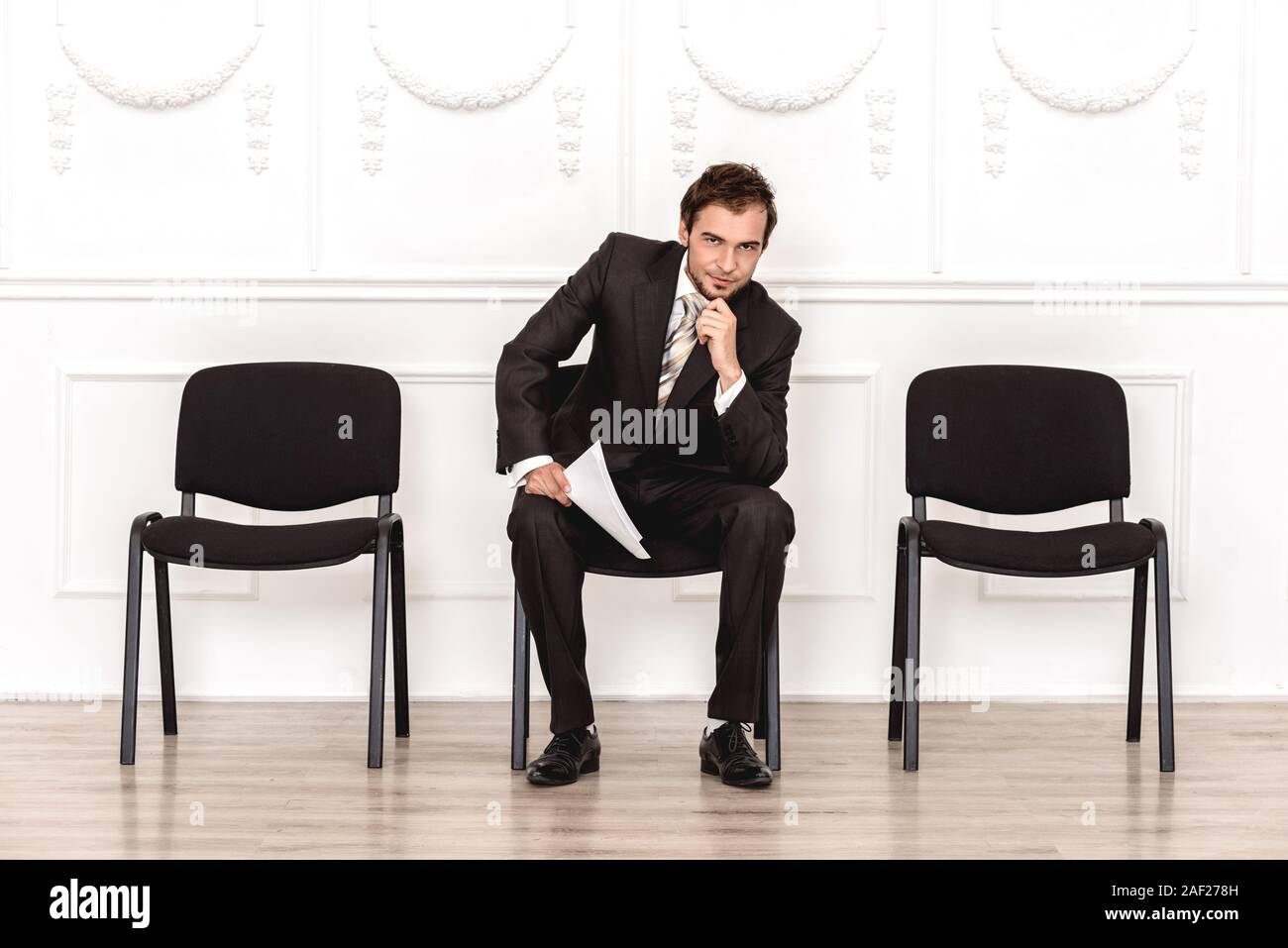 Job interview. Man sitting isolated on white waiting with resume ...