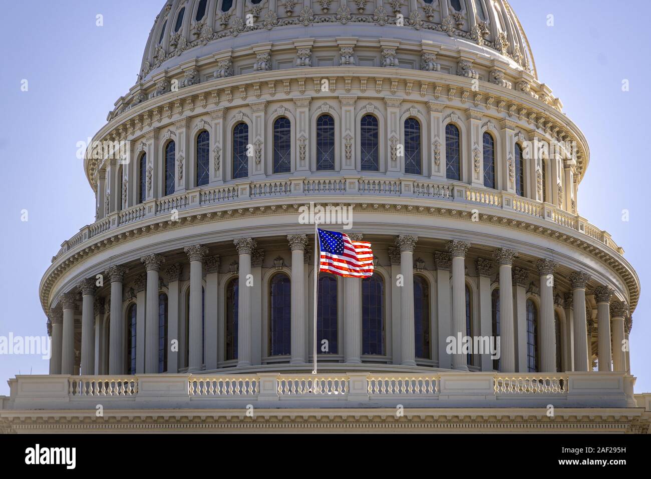 An American flag flutters in the wind in front of the Capitol Building ...