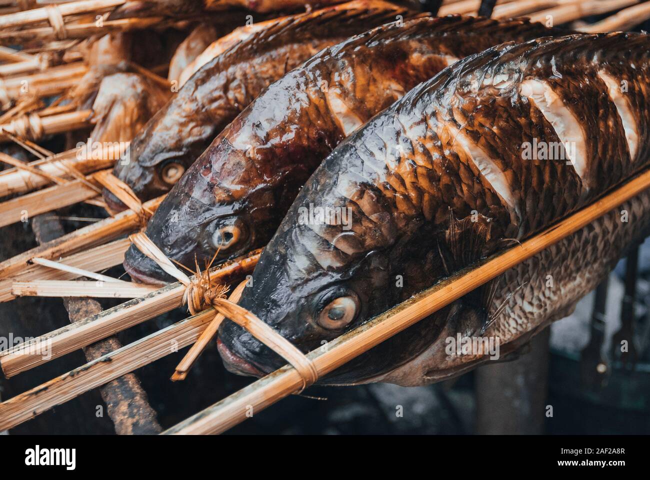 Fried fish in salt on grill on the counter of a market trader ...