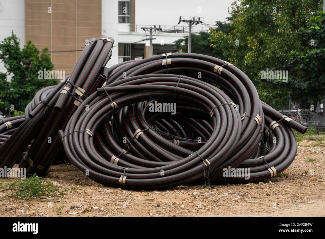 Black rubber or plastic pipes with a red lines as a construction ...