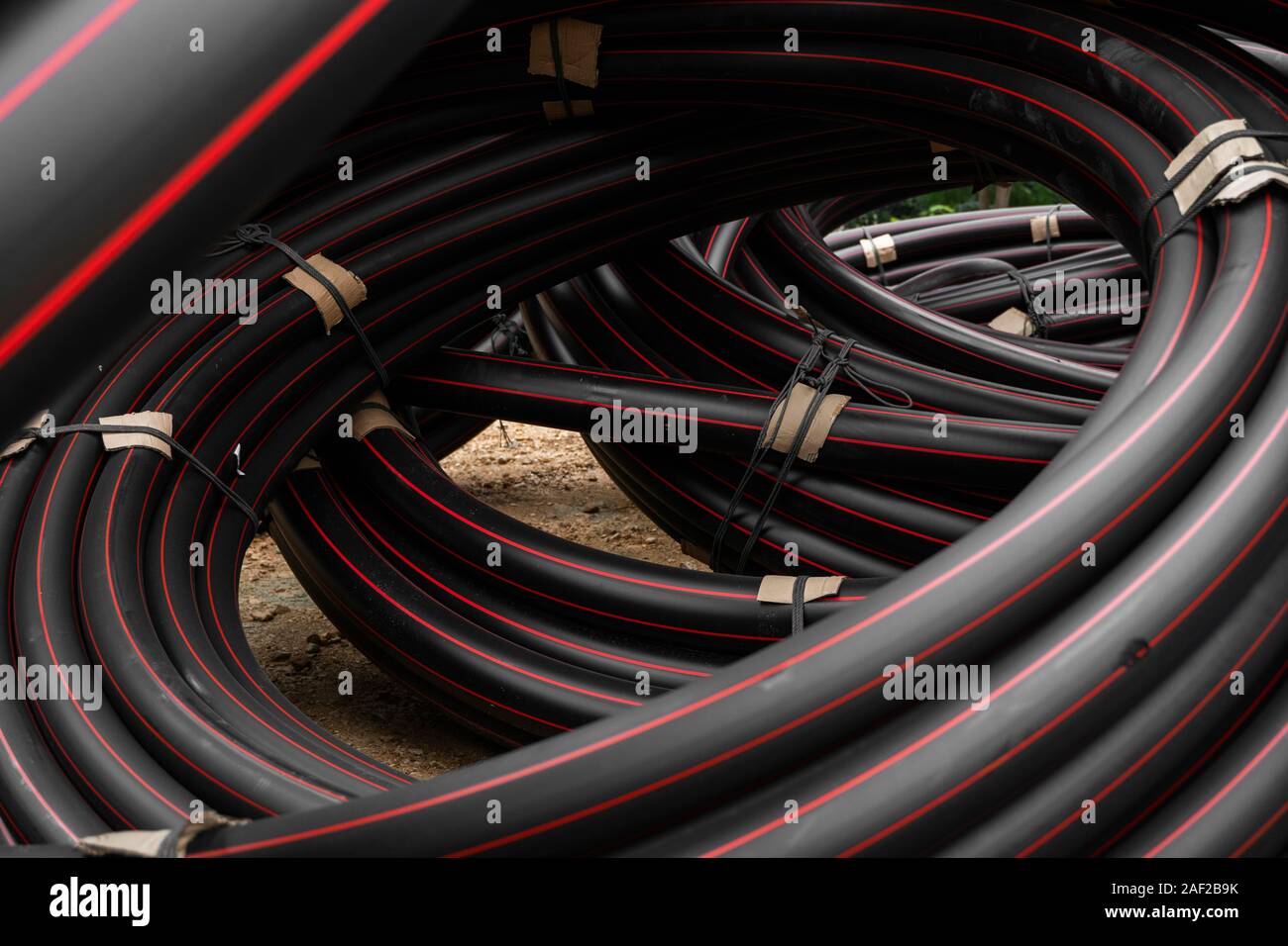 Black rubber or plastic pipes with a red lines as a construction ...