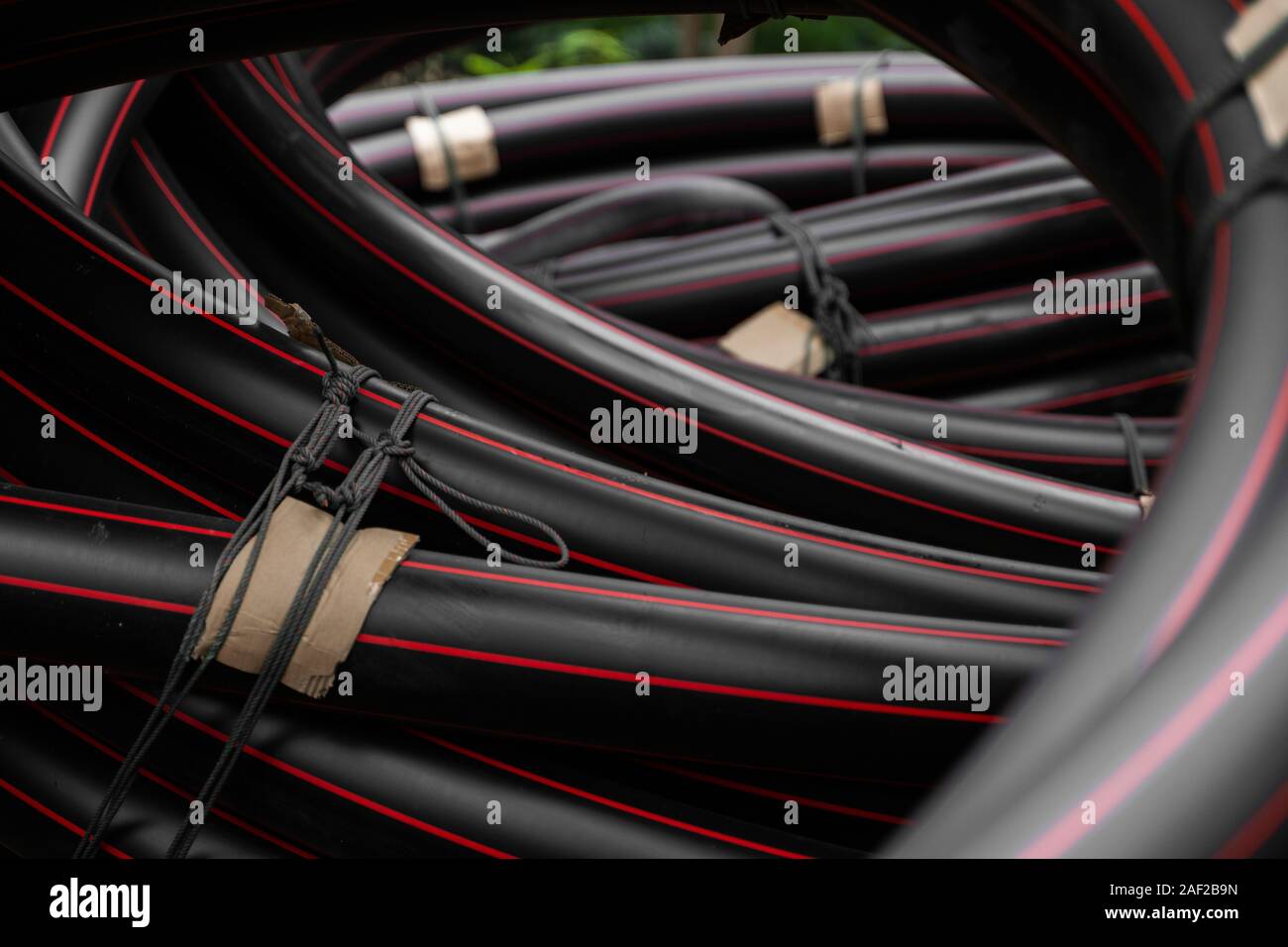 Black rubber or plastic pipes with a red lines as a construction ...