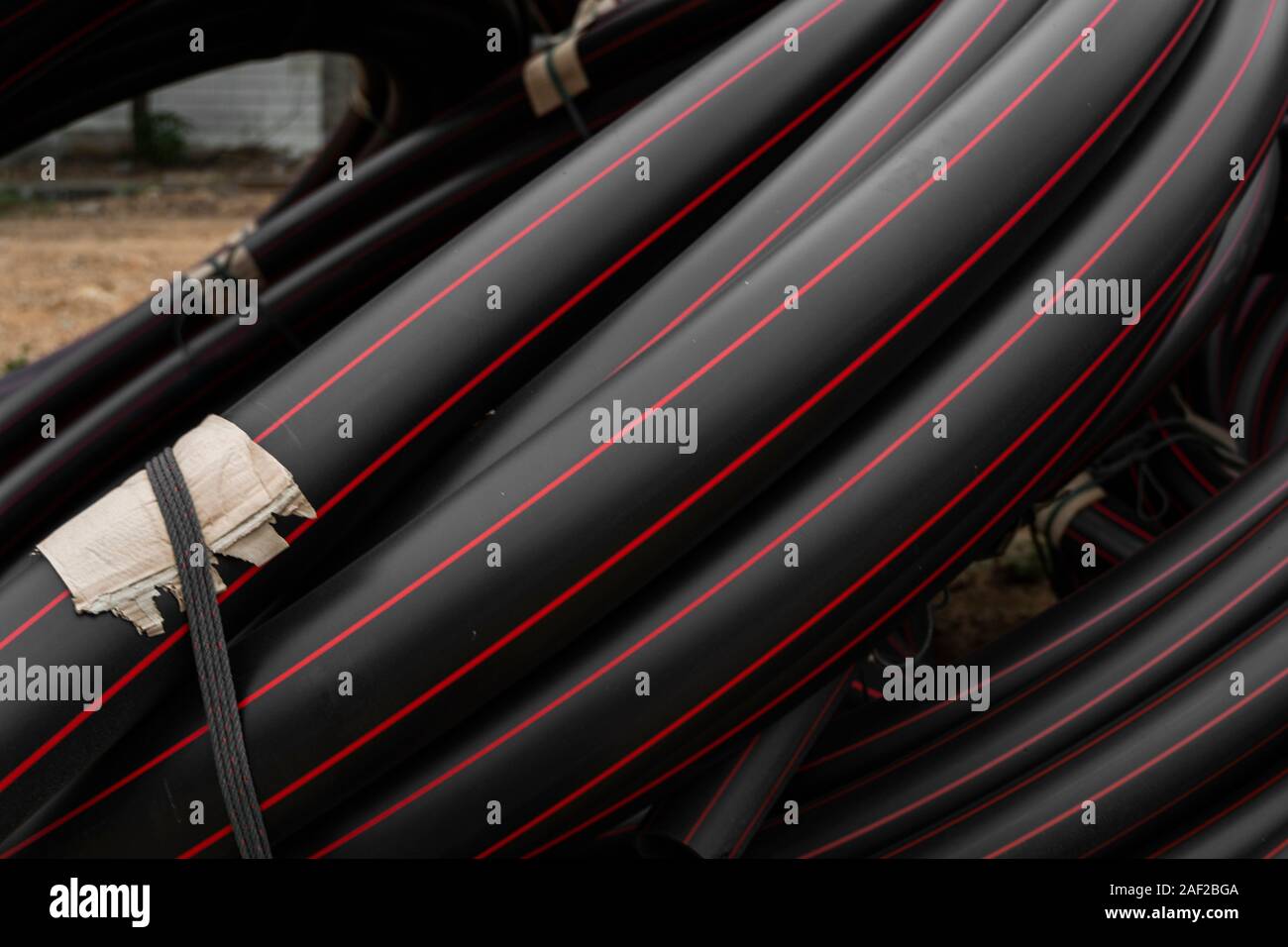 Black rubber or plastic pipes with a red lines as a construction ...