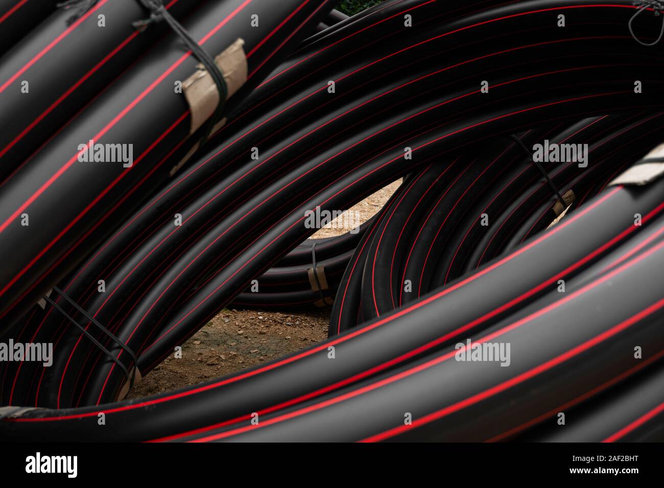 Black rubber or plastic pipes with a red lines as a construction ...