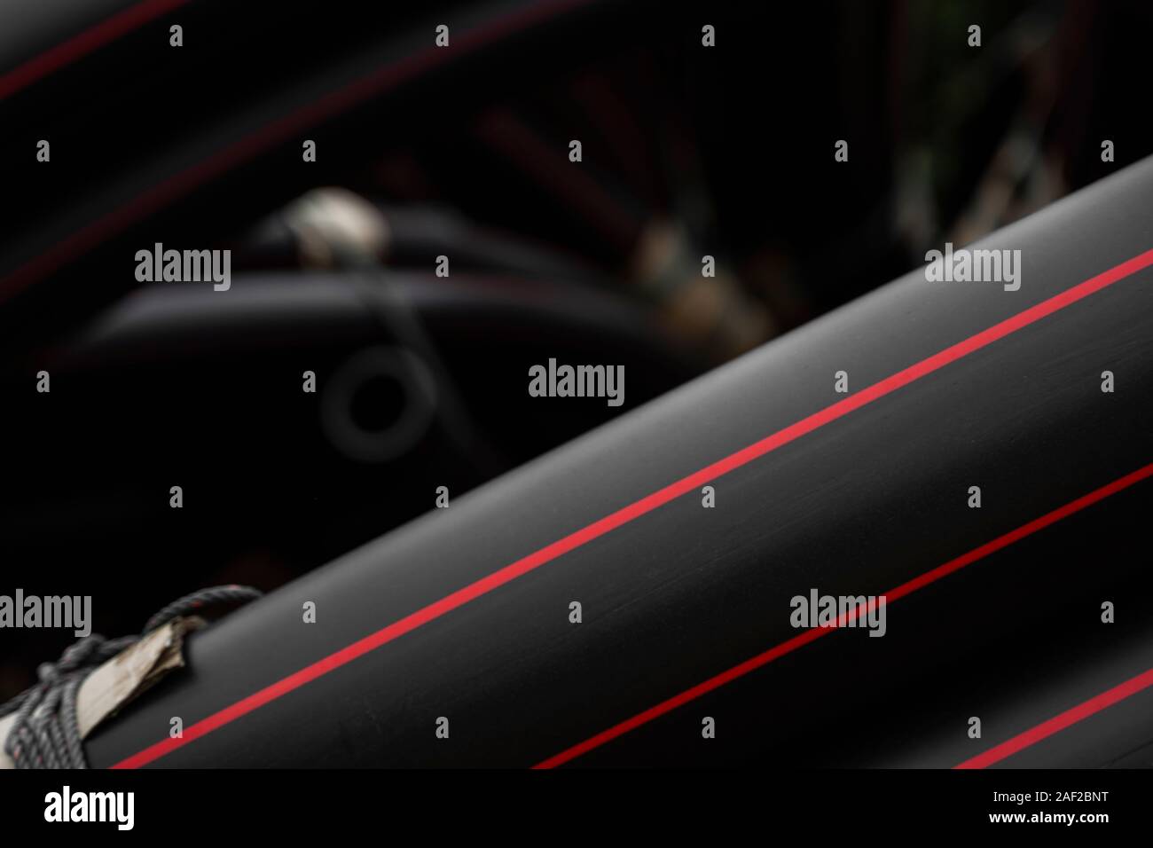 Black rubber or plastic pipes with a red lines as a construction ...
