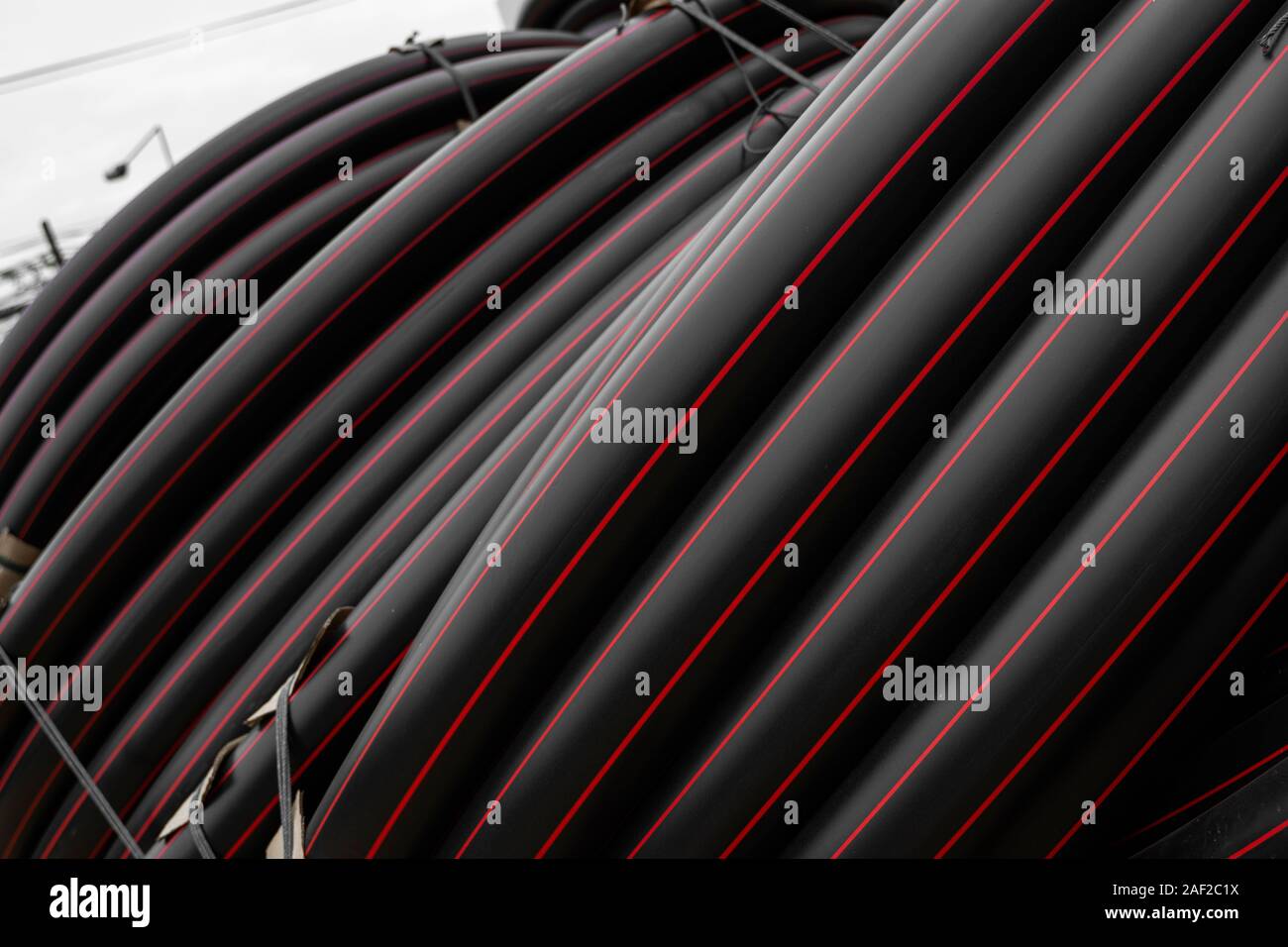 Black rubber or plastic pipes with a red lines as a construction ...