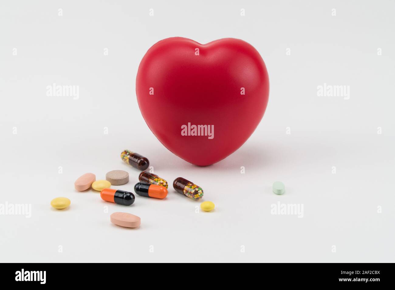 Toy heart with pills on white background. Concept healthcare ...