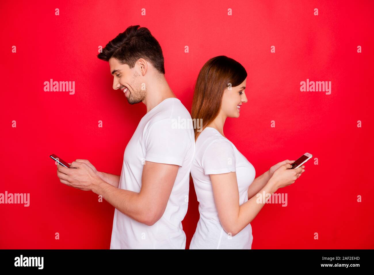 Photo of girlfriend boyfriend standing back to back chatting to each ...