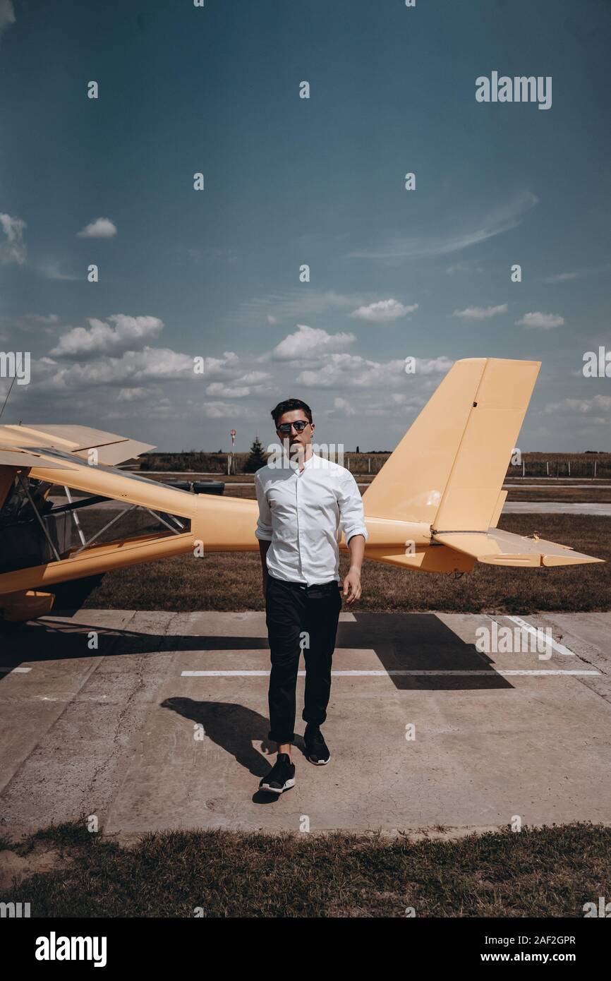 A man standing on the background of a small single engine plane Stock ...
