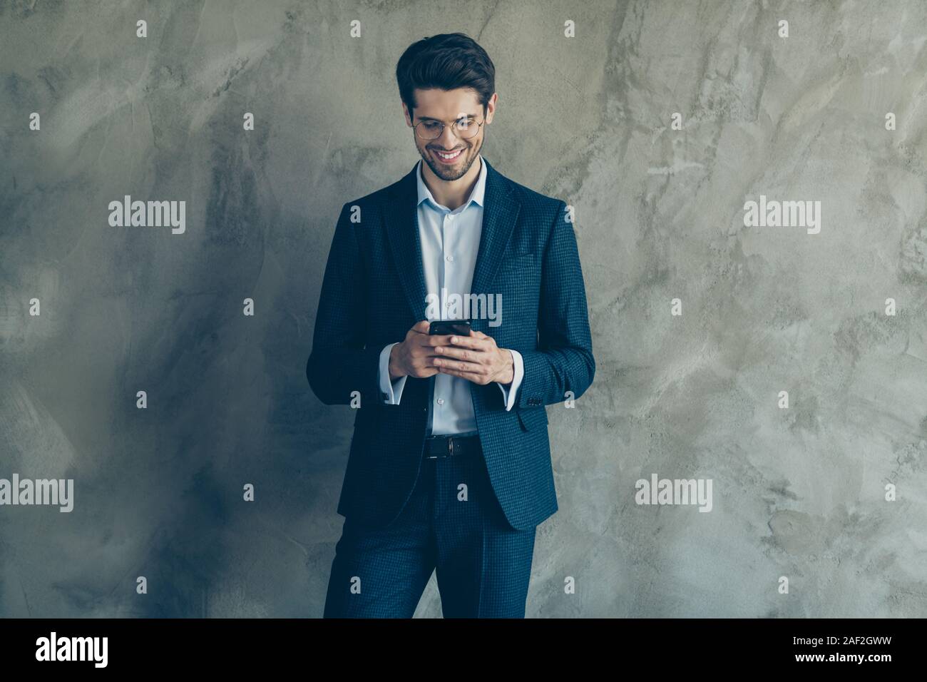 Portrait of positive cheerful ceo worker using smartphone send sms to ...