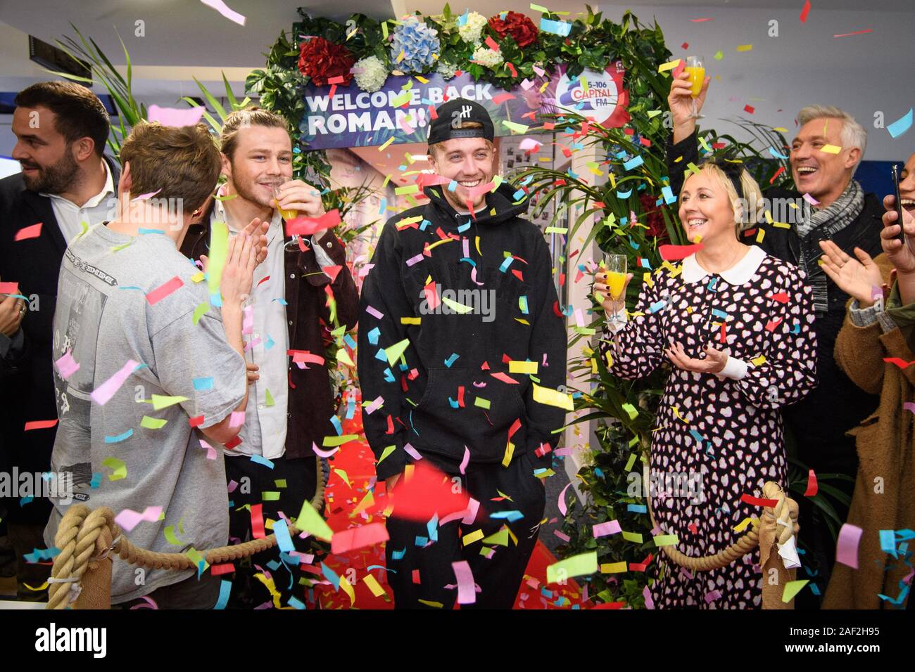 Capital DJ Roman Kemp (centre) is greeted by friends and family ...