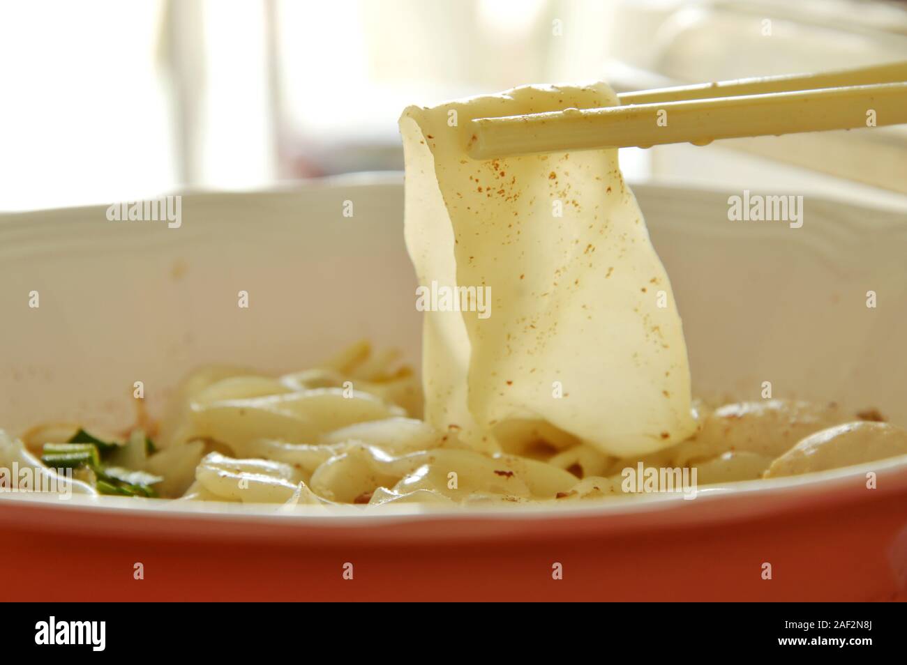 large rice noodle with braised pork in soup picking by chopstick Stock ...
