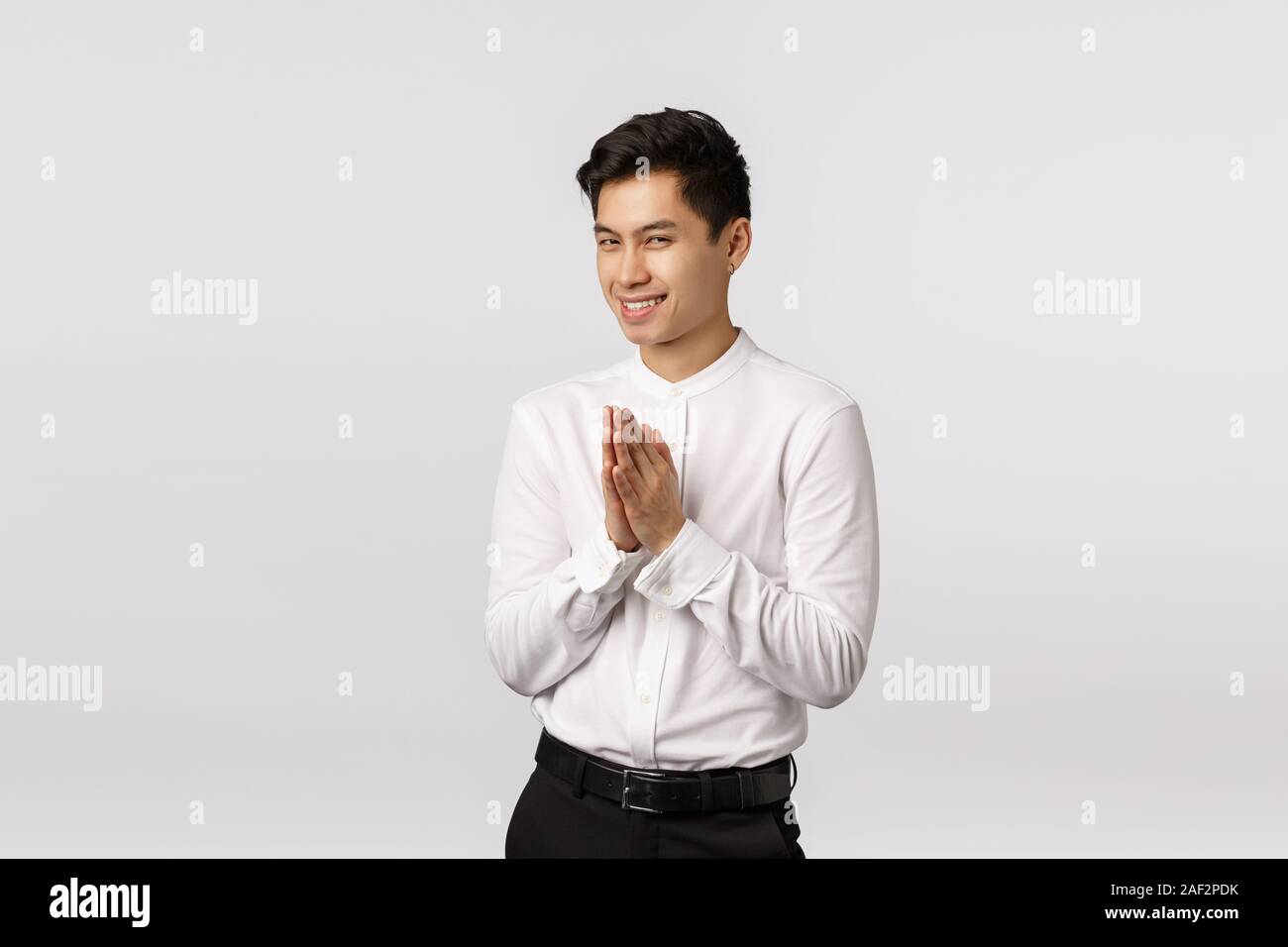 Hideous, sly handsome young asian male entrepreneur have something evil ...