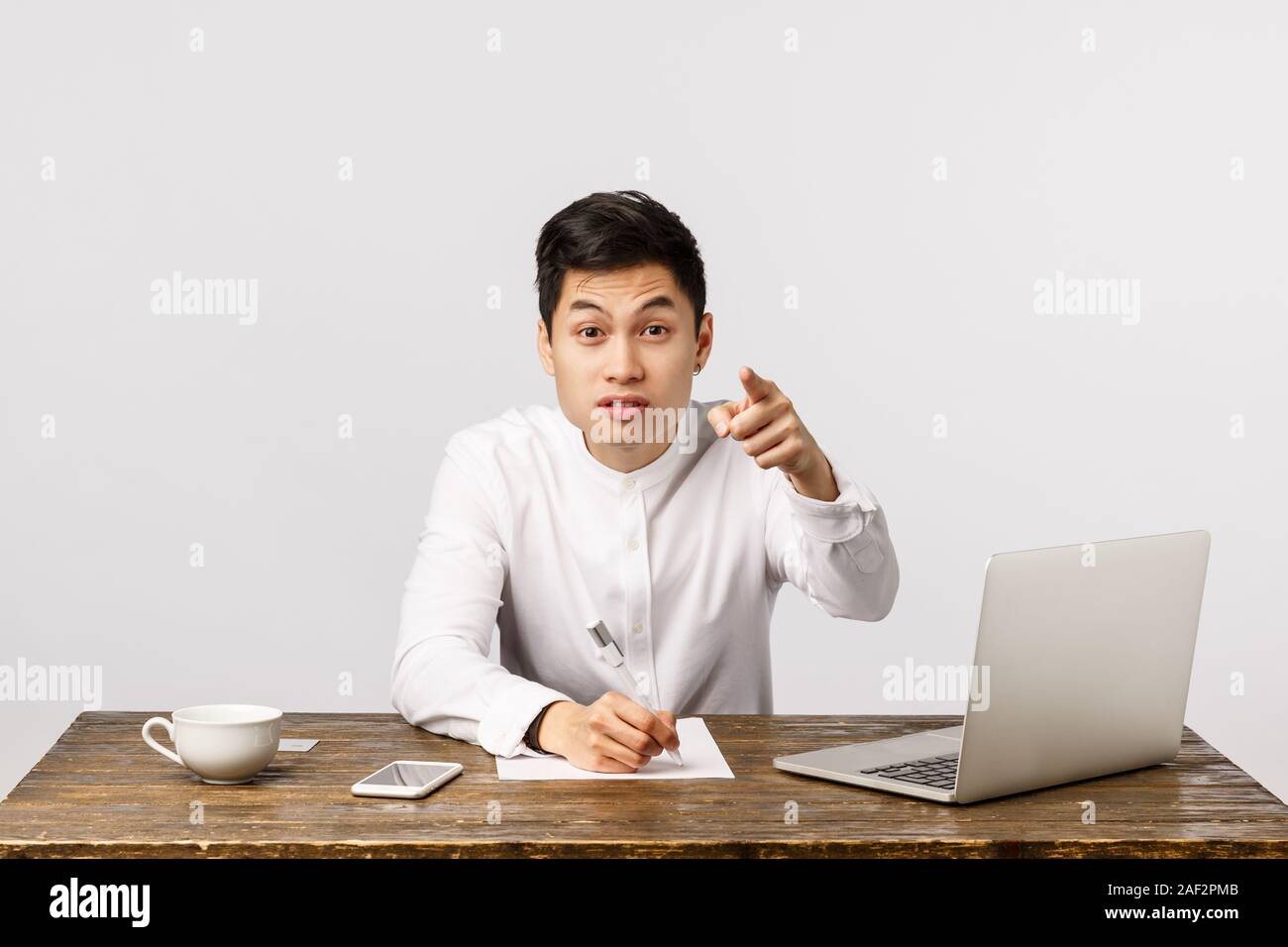 Get out. Serious-looking pissed boss writing down notes with pen on ...