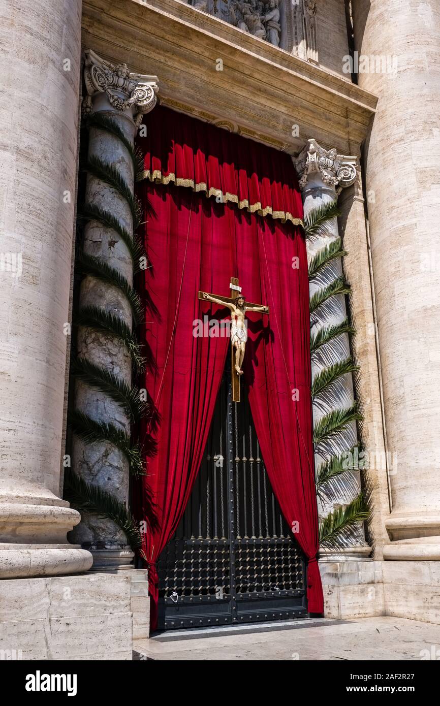The statue of Jesus Christ at a cross attached to the red curtain of an ...