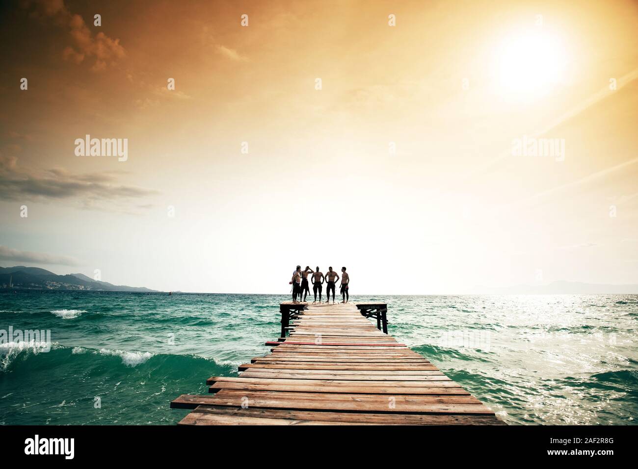 A group of divers on the pier in sunset light Stock Photo - Alamy