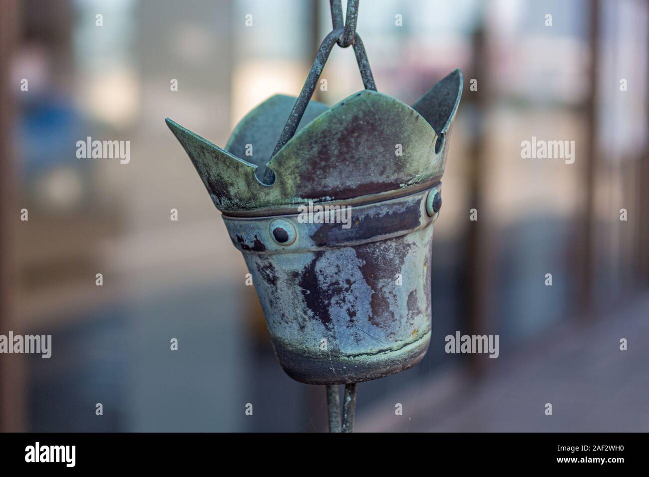 Ornamental cast metal water cup on traditional Japanese rain chain ...