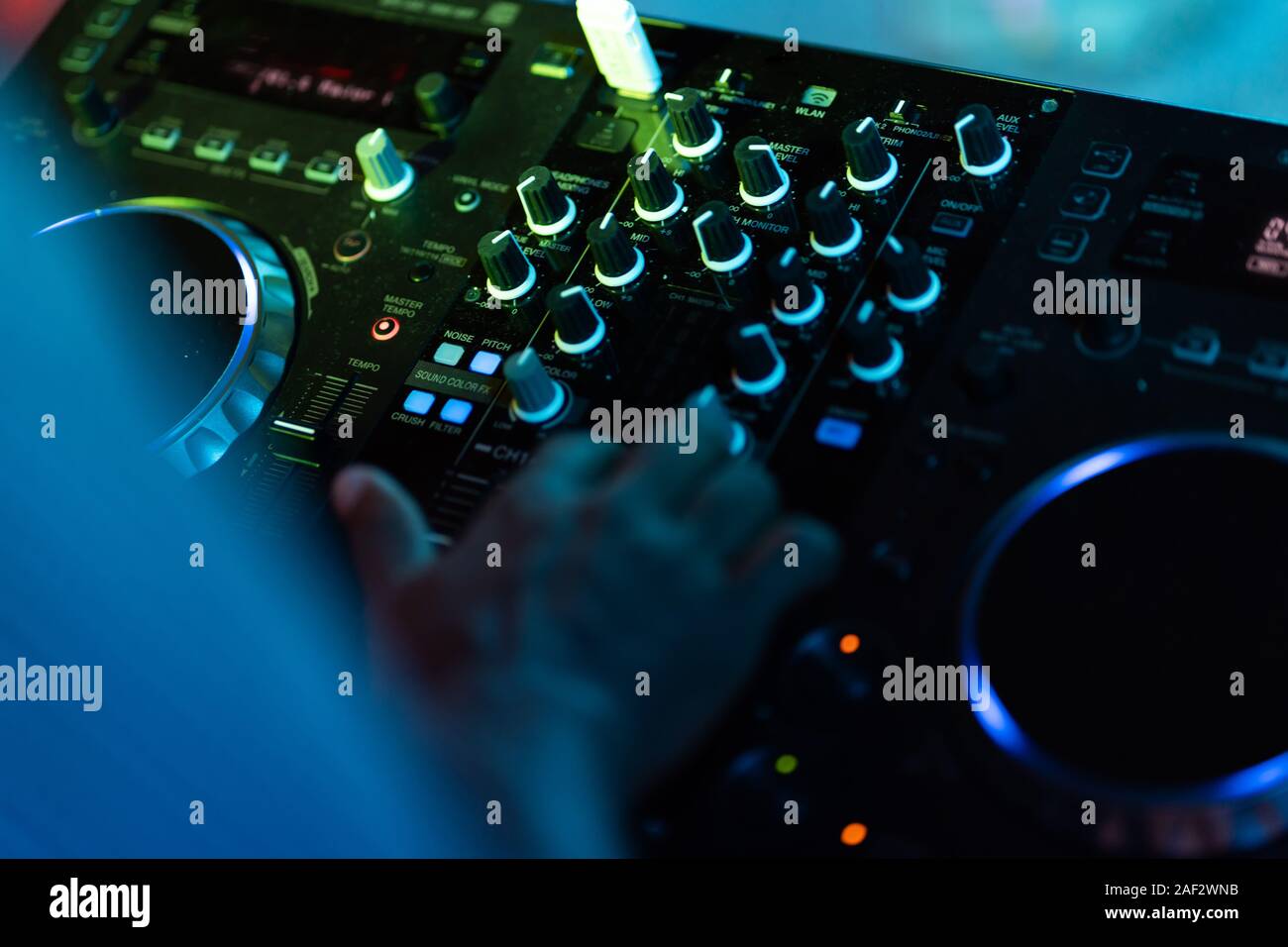 club dj plays music on stage in nightclub.Hand of disc jockey adjusting ...