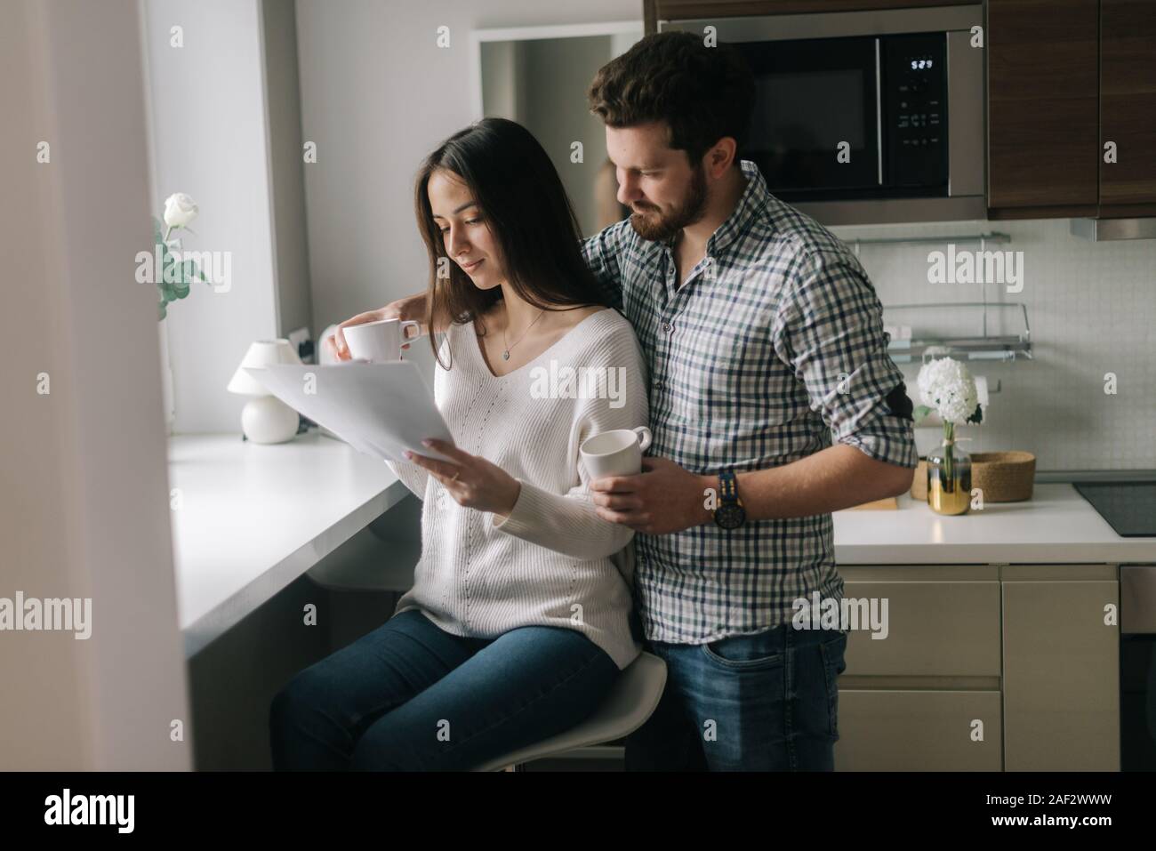 Lovely happy couple is reading documents Stock Photo - Alamy