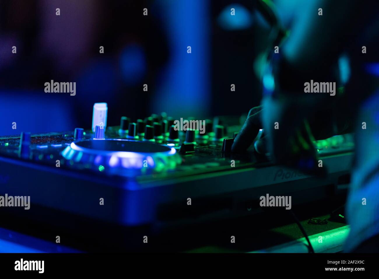 club dj plays music on stage in nightclub.Hand of disc jockey adjusting ...