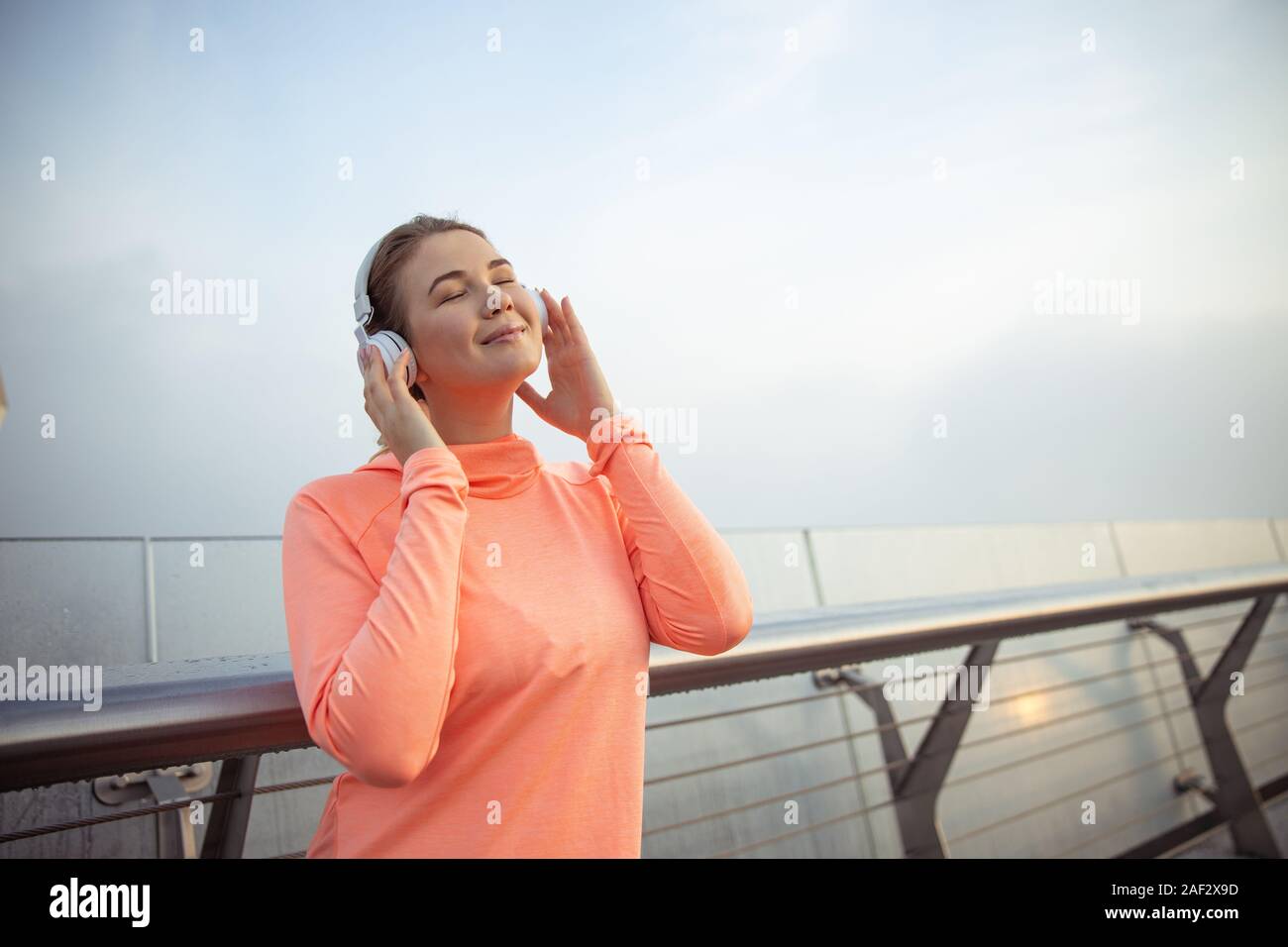 Smiling lady listening to music through wireless headphones Stock Photo ...