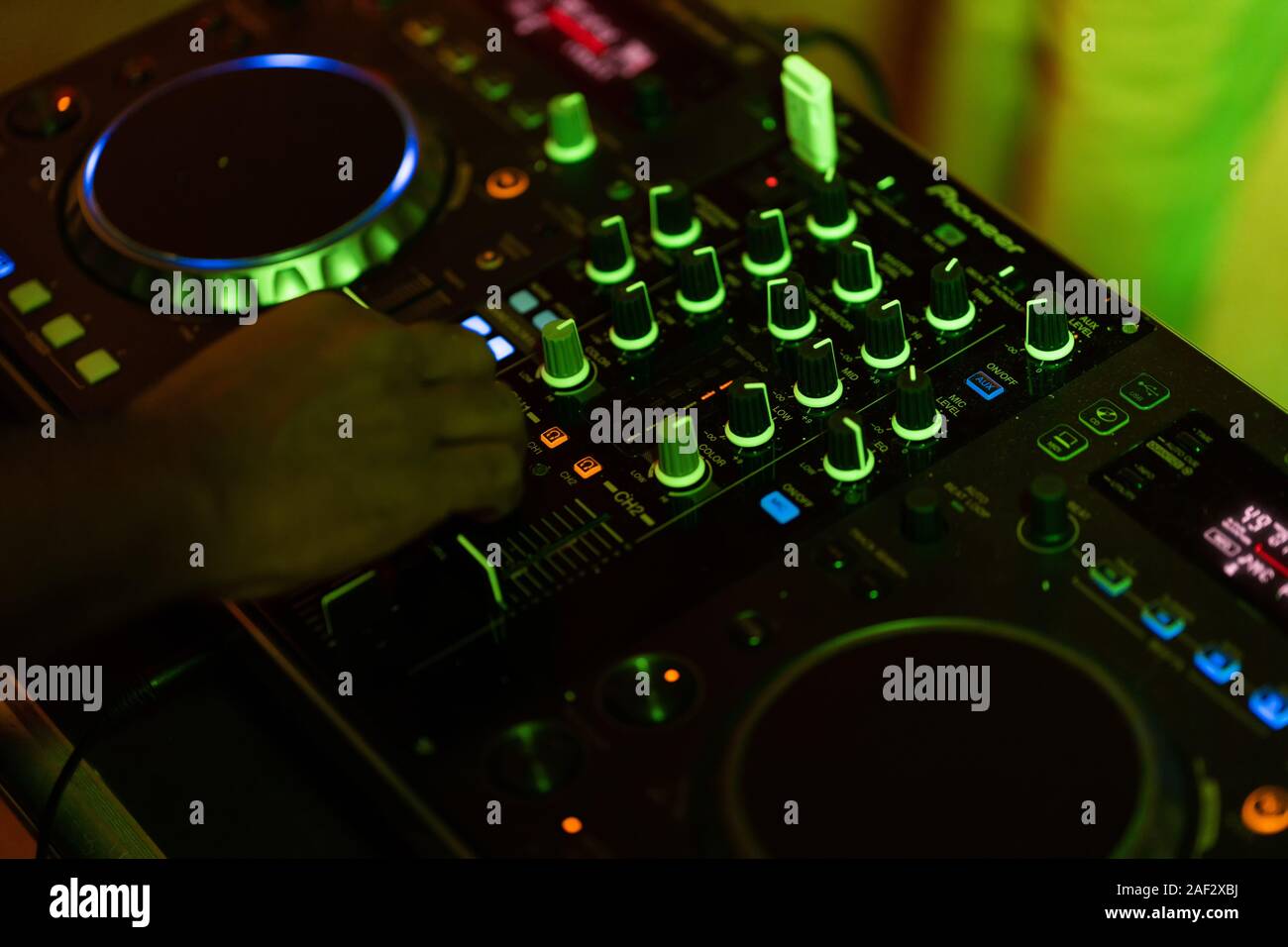 club dj plays music on stage in nightclub.Hand of disc jockey adjusting ...