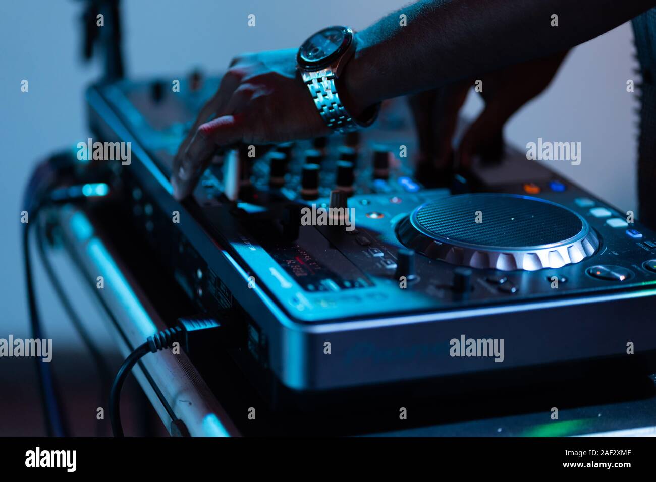 club dj plays music on stage in nightclub.Hand of disc jockey adjusting ...