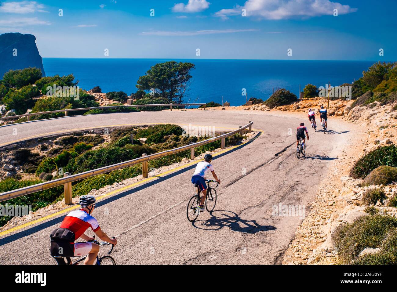 Teamwork sport photo, group of athletes on road bicycle ride by the sea ...