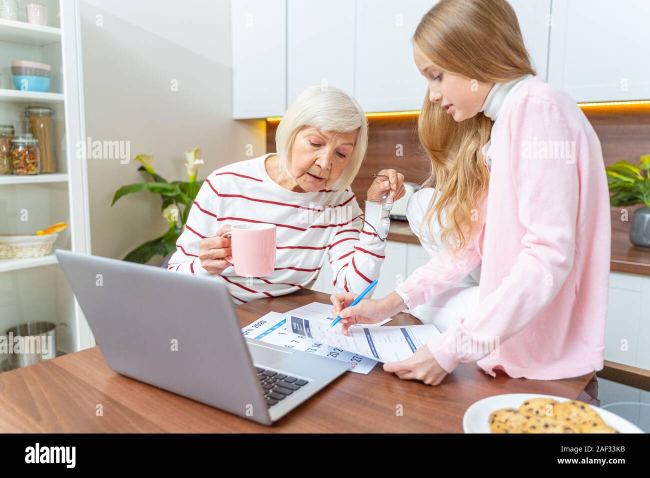 Child helping elderly with laptop hi-res stock photography and images ...